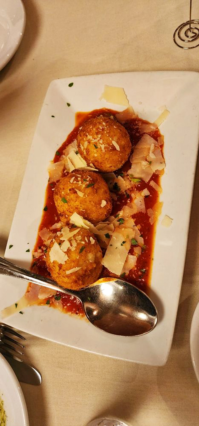 Golden arancini balls: Italy's greatest contribution to spherical food, where crispy exteriors give way to creamy risotto bliss.