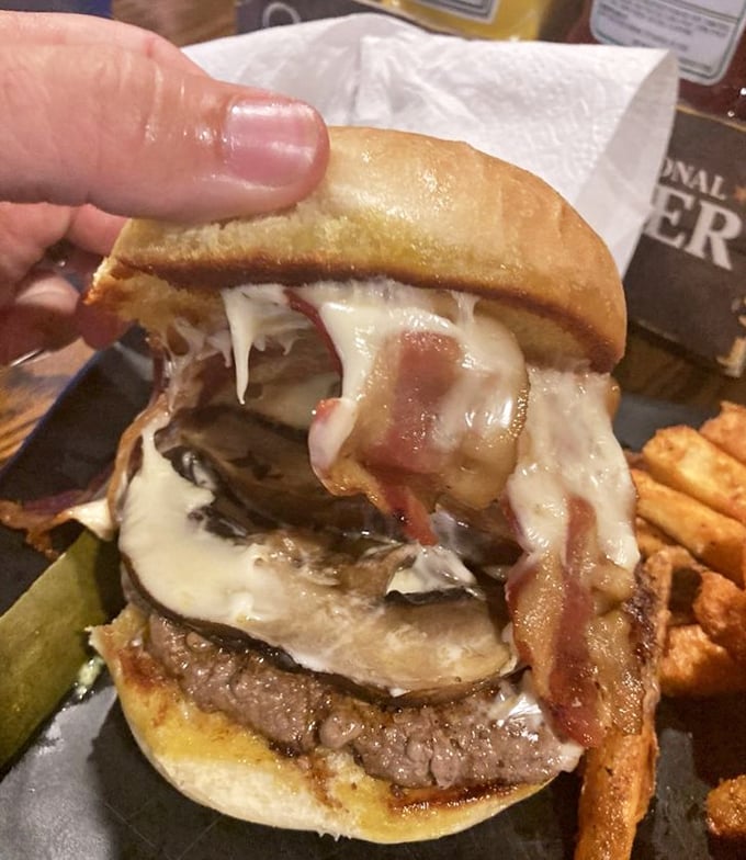 Melty cheese cascades over bacon and mushrooms like a savory waterfall. This isn't just a burger&mdash;it's architecture you can eat.
