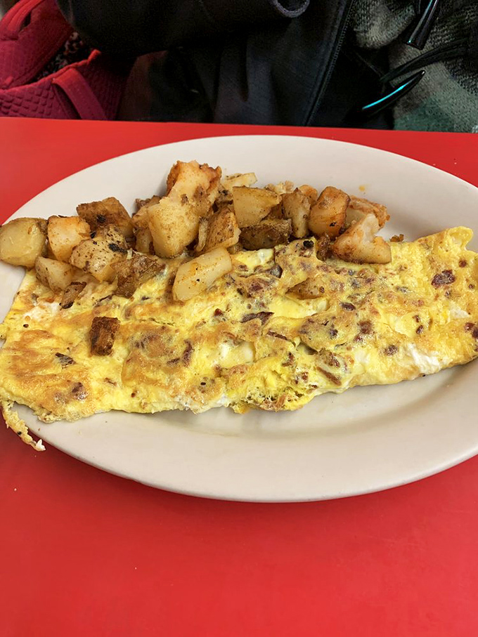 Breakfast perfection on a plate &ndash; a golden omelet nestled beside those famous home fries, the kind of honest cooking that makes morning people out of night owls.