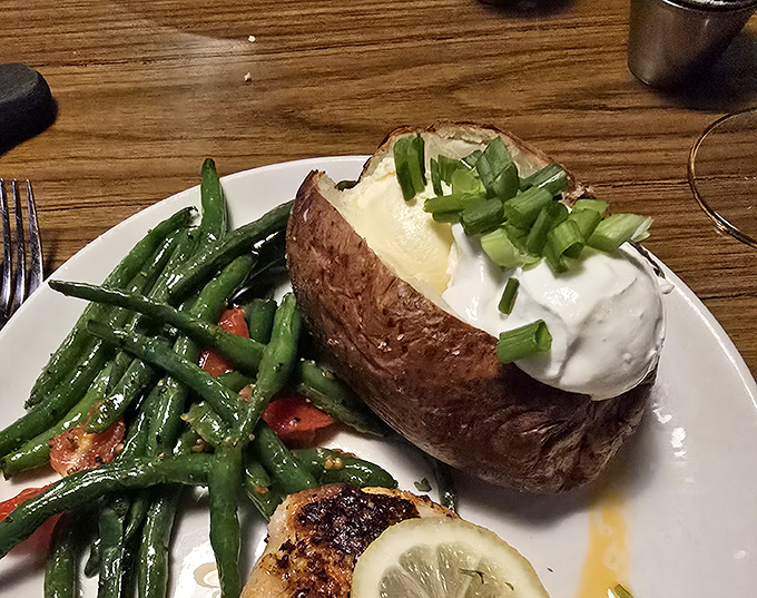 The humble baked potato, elevated to art form with a dollop of sour cream and fresh chives. Comfort food that hugs you from the inside.