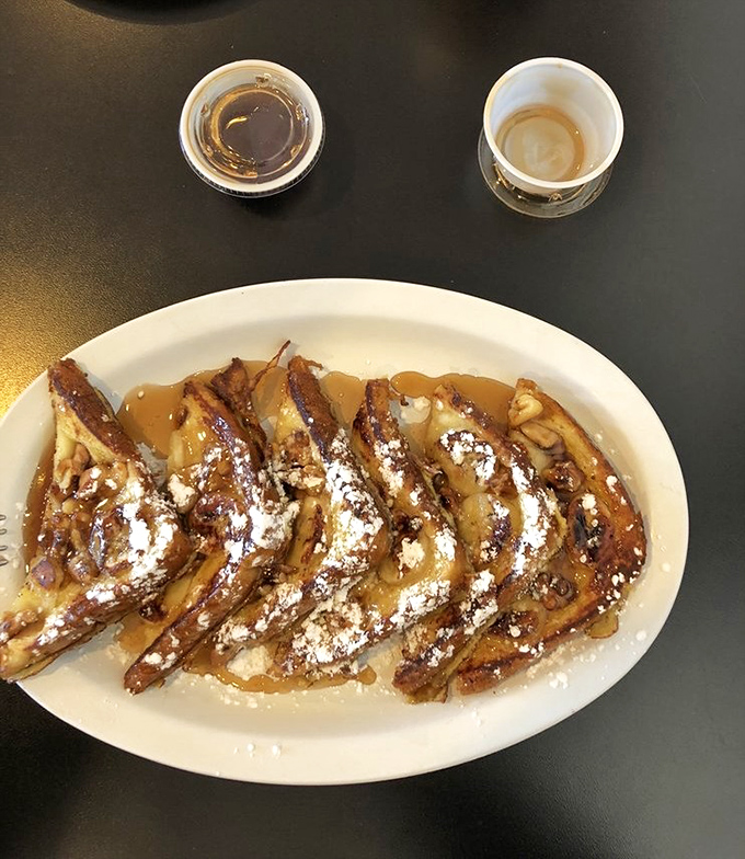 French toast that looks like it belongs in a dessert hall of fame. Those caramelized bananas and powdered sugar are performing a sweet symphony.