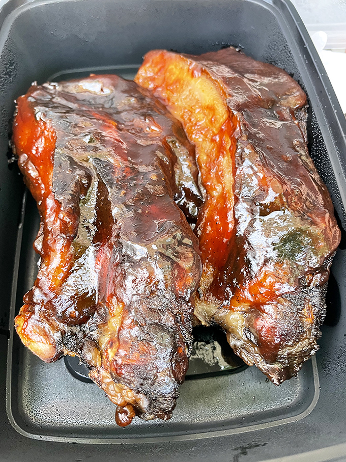 These beef ribs aren't just dinner; they're prehistoric-looking meat lollipops glazed to a mahogany shine that would make furniture jealous.