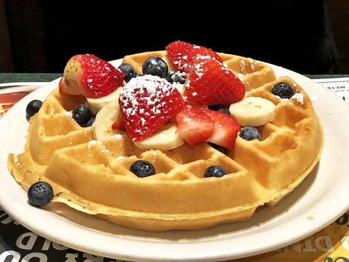 A Belgian waffle adorned with nature's candy. Breakfast or dessert? The line blurs deliciously when powdered sugar enters the chat.