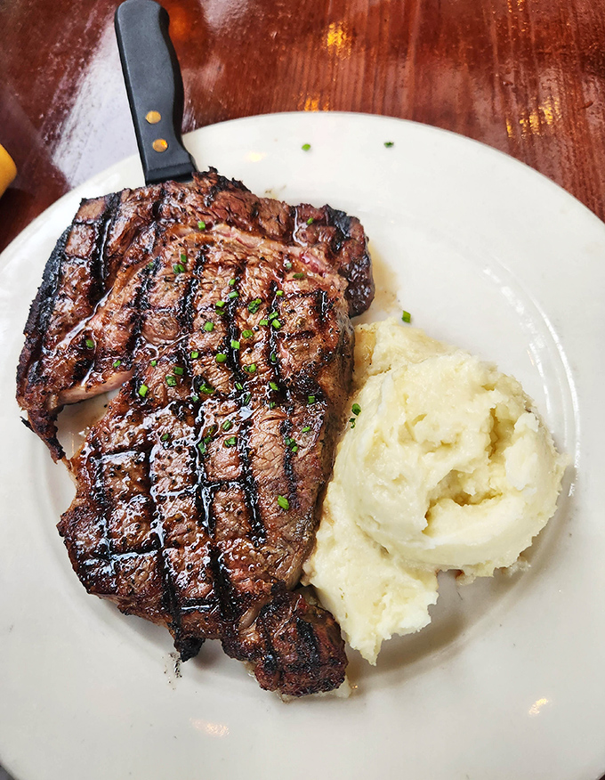 A ribeye steak with grill marks so perfect they deserve their own Instagram. The mashed potatoes aren't just a side—they're moral support.