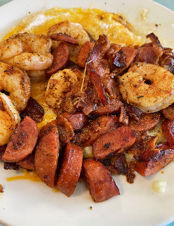 Blackened shrimp dancing with sausage atop a golden canvas of grits. This plate has more flavor than most food court meals have in their entire existence.