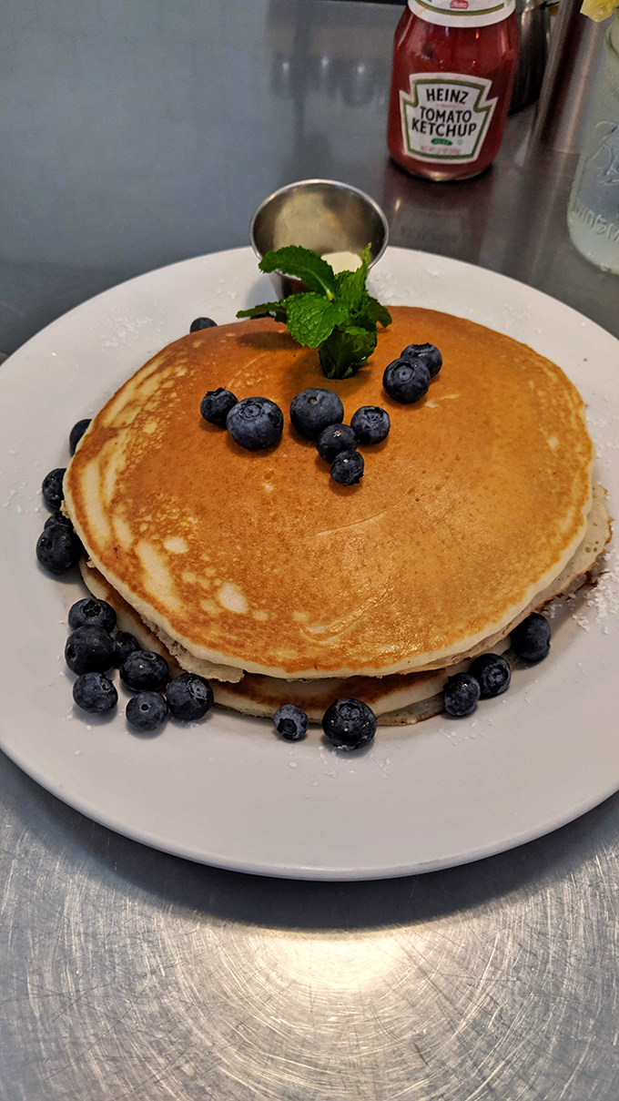 Blueberry pancakes stacked like edible skyscrapers, each floor bursting with fruit-filled happiness.