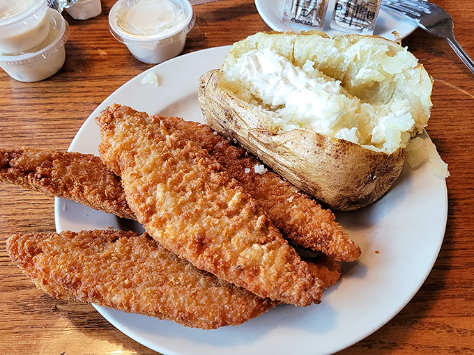 Golden-fried walleye with a loaded baked potato – the kind of honest plate that makes fancy city restaurants seem unnecessarily complicated.