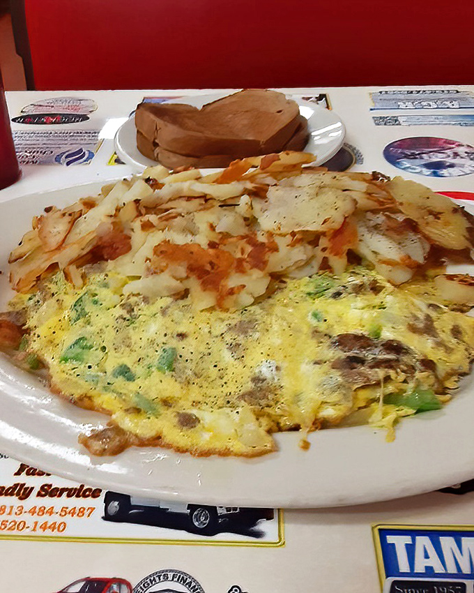 The holy trinity of breakfast: a perfectly cooked omelet, crispy hash browns, and toast waiting patiently for its butter bath.