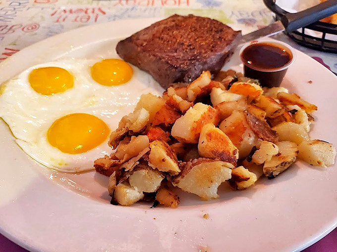 Three sunny-side-up eggs standing guard over perfectly crisped home fries and a steak&mdash;breakfast doesn't get more straightforward or satisfying than this.