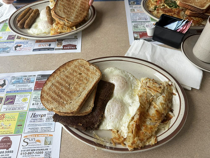 The classic American breakfast trinity: perfectly cooked eggs, crispy hash browns, and toast ready for that essential swipe through runny yolk.