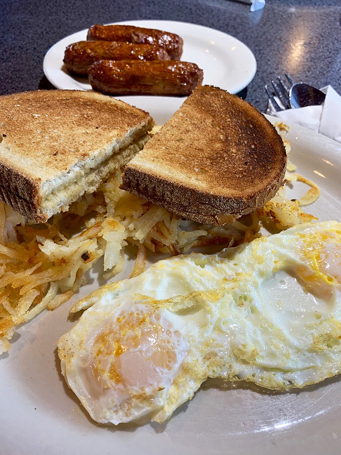 The breakfast trinity: perfectly toasted bread, eggs with just-right yolks, and hash browns that crackle with each bite.