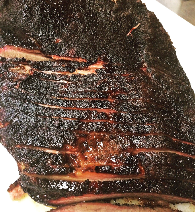 Brisket with a bark so perfect it belongs in a museum. The smoke ring is practically a halo&mdash;barbecue beatification in meat form.