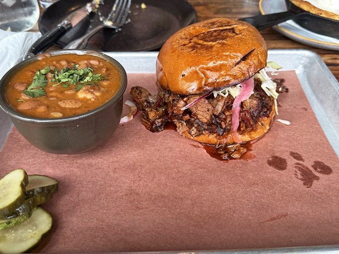 This isn't just a sandwich; it's an architectural marvel of smoked meat, pickled onions, and sauce, requiring both hands and possibly a bib commitment.