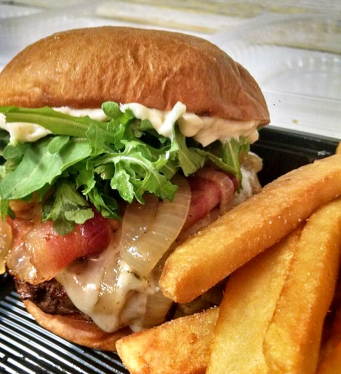 A burger that requires both hands, a stack of napkins, and absolutely no first-date jitters if you plan to tackle this beautiful beast.