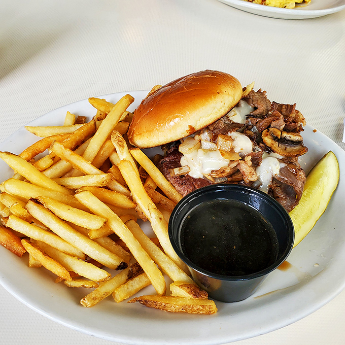 A proper diner burger should require both hands and several napkins. This beauty, with its golden fries and pickle spear, delivers on that sacred promise.