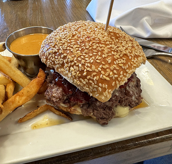 The burger arrives like a sesame-crowned monarch, juices flowing freely—a reminder that sometimes happiness is simply well-executed simplicity.
