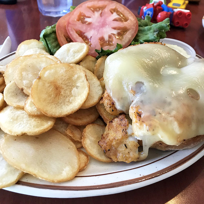 The Cajun Cod Melt sandwich with its golden potato chips isn't just food&mdash;it's edible architecture. That melted cheese is making a dramatic entrance.