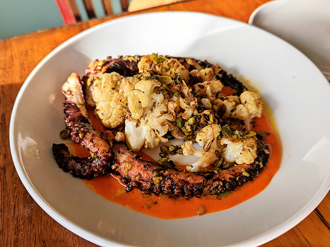 Charred octopus dancing with cauliflower on a stage of bright orange sauce—seafood theater that deserves a standing ovation.