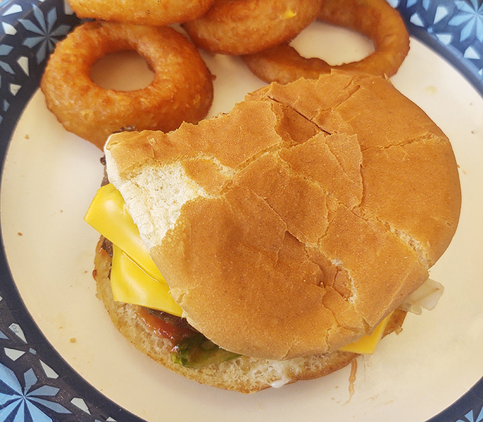 A cheeseburger and onion rings that remind you why simple food, done right, will always trump fancy culinary trends. This is America on a plate.