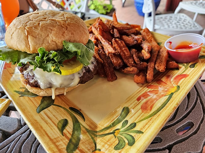 A burger that requires both hands and a strategy. Those sweet potato fries look like they've been kissed by the perfect amount of salt.
