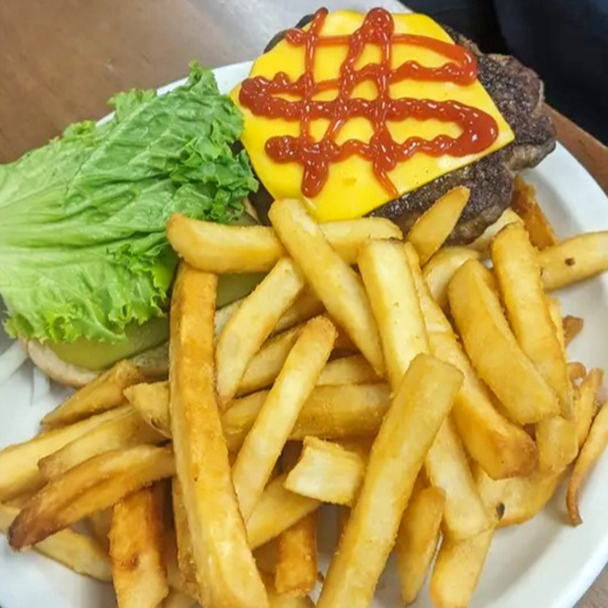 A burger that requires a game plan before the first bite. Notice the architectural precision of those perfectly crisp fries.