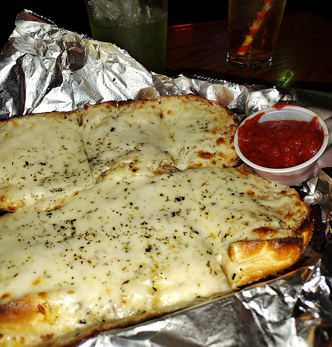 Cheesy garlic bread that demands to be pulled apart slowly, creating those satisfying cheese bridges that are half the fun of eating it.