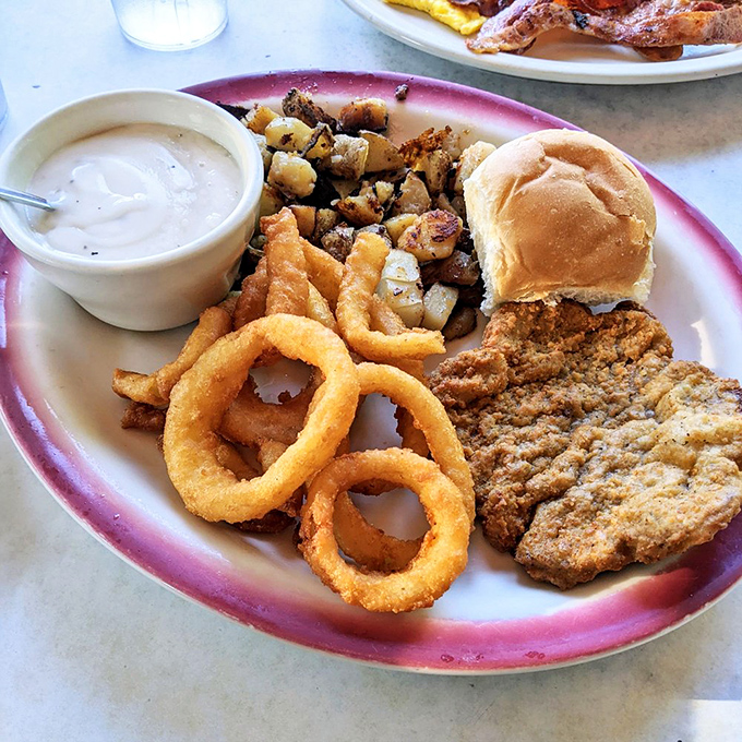 Country fried steak with onion rings&mdash;the kind of plate that makes diet books spontaneously combust and nutritionists look the other way. Worth every bite.