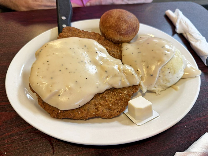 This chicken fried steak swimming in creamy pepper gravy isn't just a meal &ndash; it's a Southern hug on a plate.