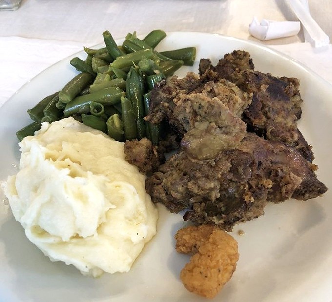 Meatloaf, mashed potatoes, and green beans&mdash;the holy trinity of comfort food arranged on a plate like edible artwork for the soul.