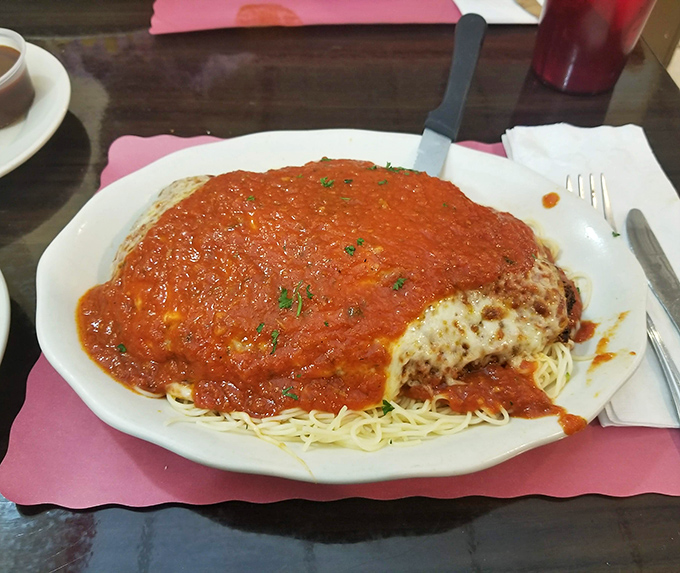 When Italian comfort food calls, this chicken parmigiana answers with a blanket of marinara and a bed of pasta that feels like a hug.