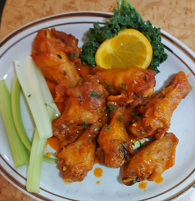 Buffalo wings with celery sticks—a simple pleasure done right. The sauce clings to each wing like it was made for no other purpose.