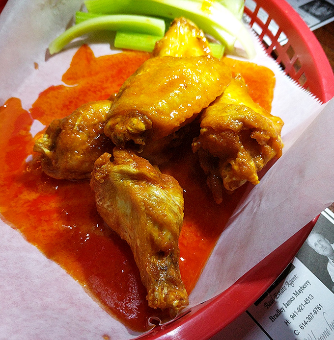 These buffalo wings glisten with sauce perfection, promising the kind of heat that builds character and demands cold beer.