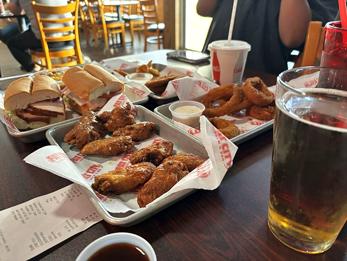 Wings and sandwiches spread across the table like a carnivore's dream. The kind of feast that turns strangers at neighboring tables into friends.