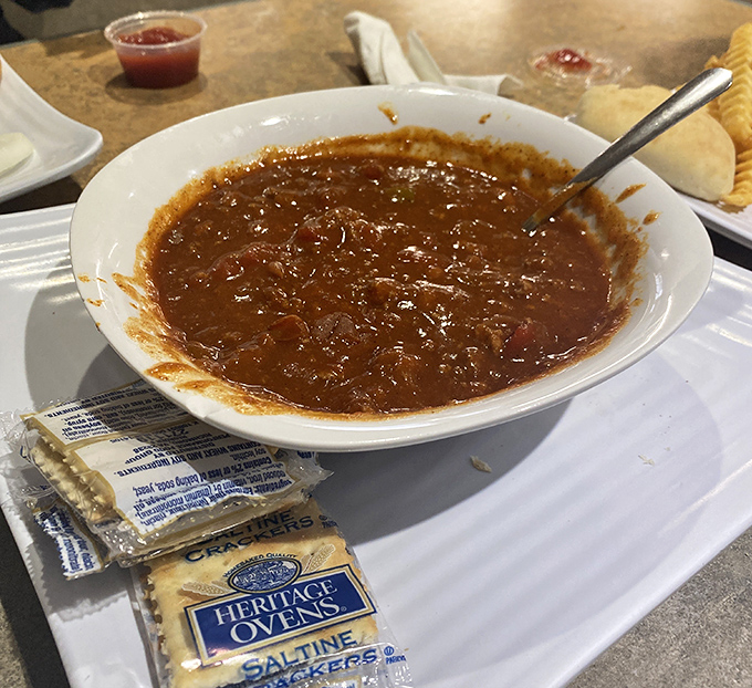 A bowl of chili that looks like it could cure whatever ails you, served with crackers for that essential textural contrast.