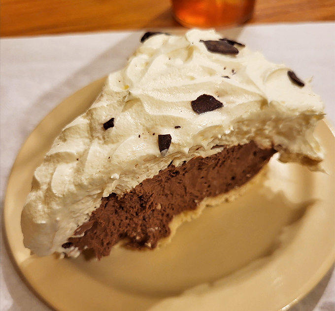 A chocolate cream pie topped with clouds of whipped cream – the kind that makes you consider ordering dessert first next time.