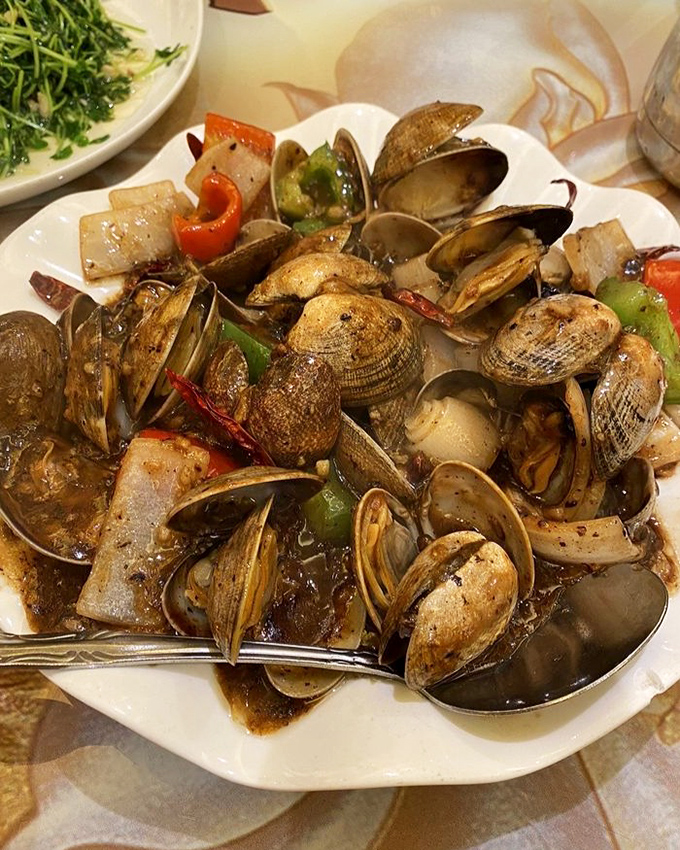 These clams in black bean sauce aren't just swimming&mdash;they're performing synchronized flavor Olympics with bell peppers and aromatics.