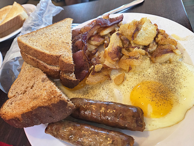 The breakfast plate that launched a thousand road trips &ndash; eggs, bacon, toast, and hash browns arranged like the four elements of morning perfection.