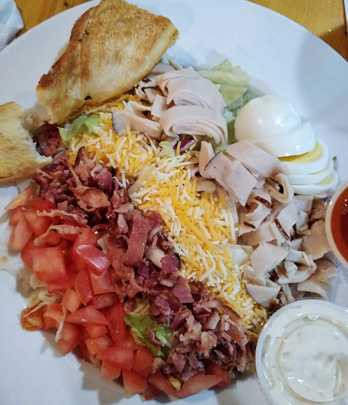 A Cobb salad arranged with the precision of an artist, where each ingredient gets its own territory like a delicious edible map of flavor country.
