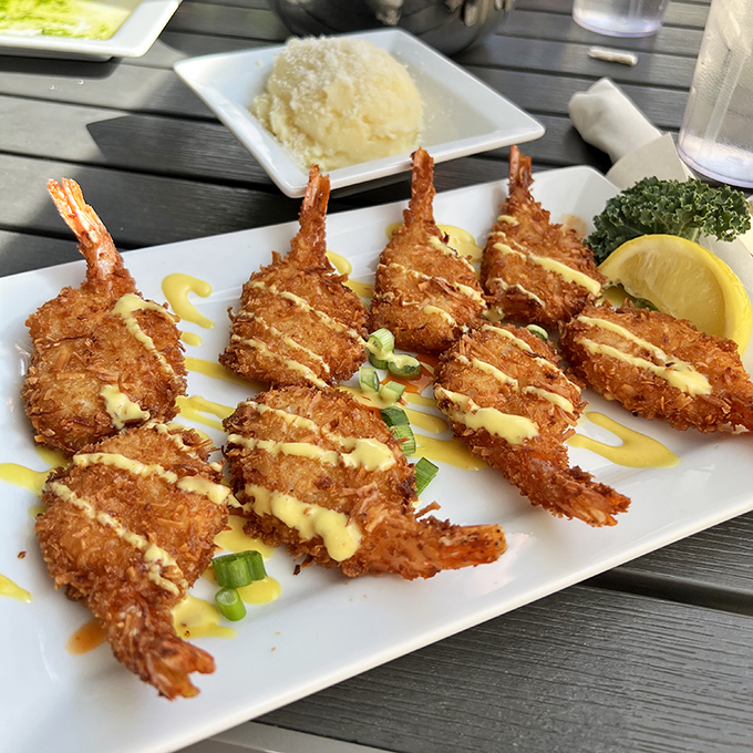Golden coconut shrimp lined up like delicious soldiers, ready to march straight into flavor heaven with that bright yellow sauce.