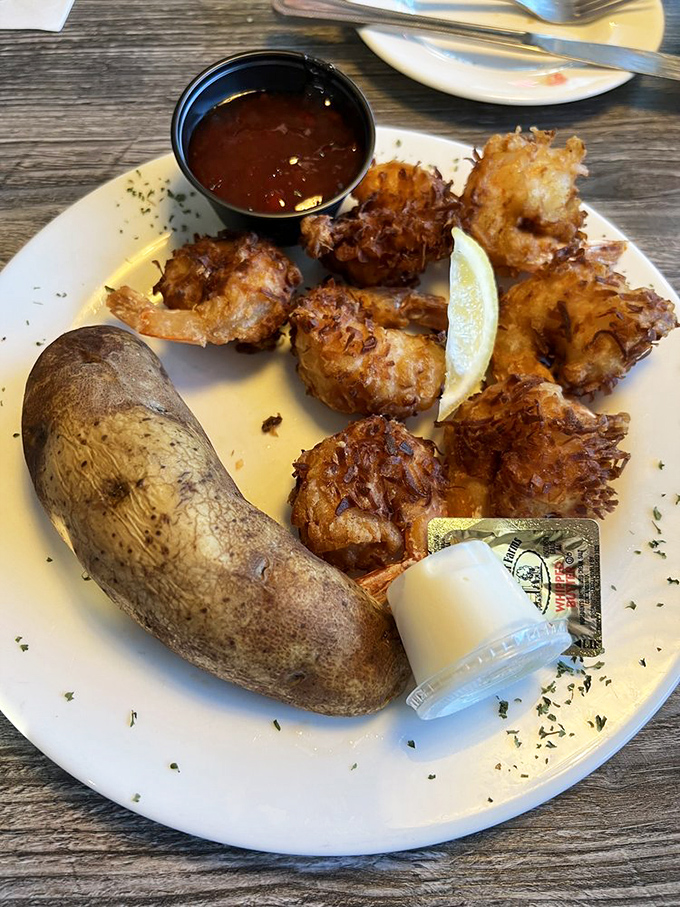 Coconut shrimp that delivers the perfect crunch-to-sweetness ratio, paired with a baked potato that's clearly living its best life.