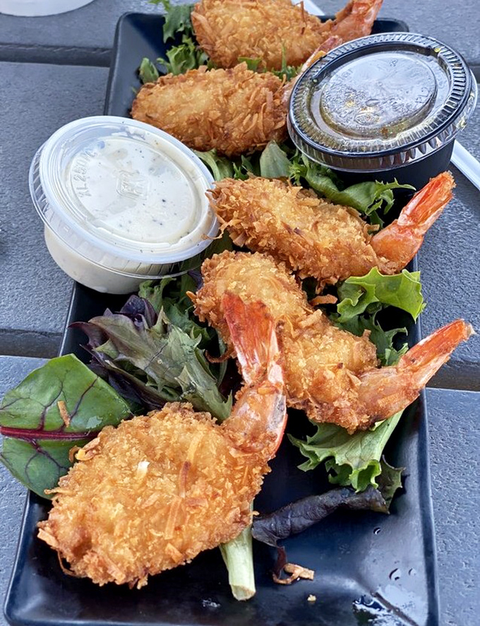 Golden coconut shrimp that crunch like autumn leaves but taste infinitely better than your childhood rake-jumping memories.