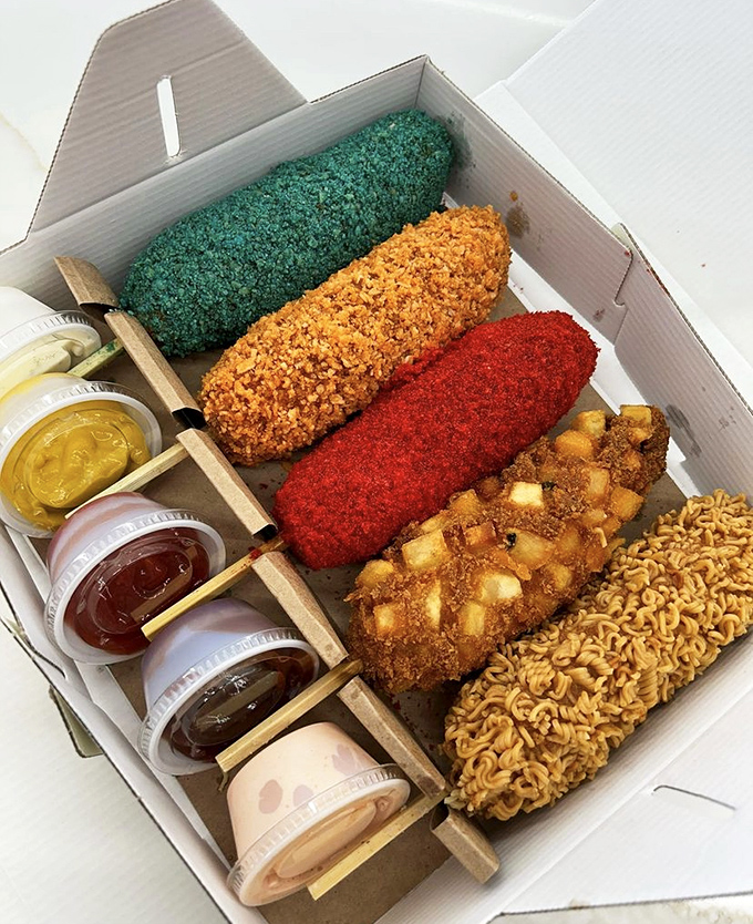 A box of Korean rice dogs in technicolor glory&mdash;from ramen-crusted to potato-studded&mdash;with dipping sauces standing by for duty.