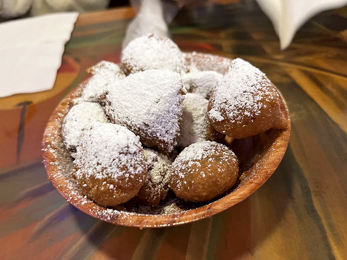 Golden-brown beignet-like treasures dusted with powdered sugar &ndash; dessert masquerading as an appetizer, and nobody's complaining.
