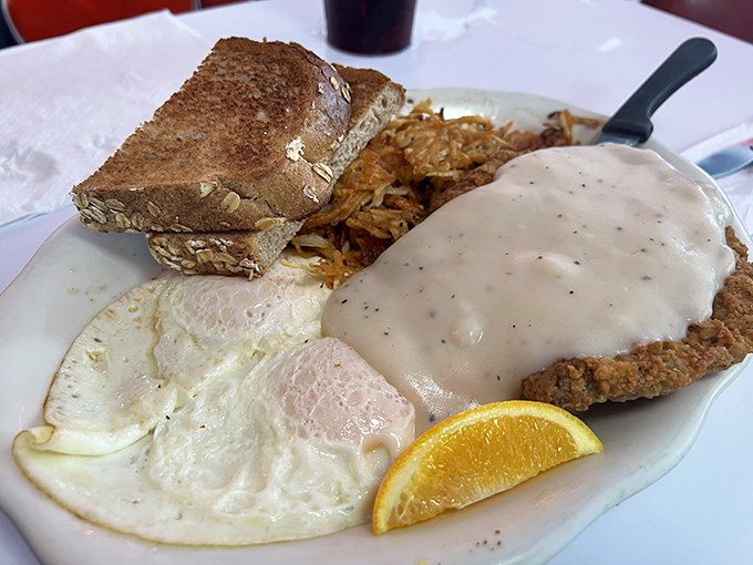 Country fried steak smothered in peppery gravy with eggs sunny-side up—a breakfast that fuels Florida adventures or justifies afternoon naps.