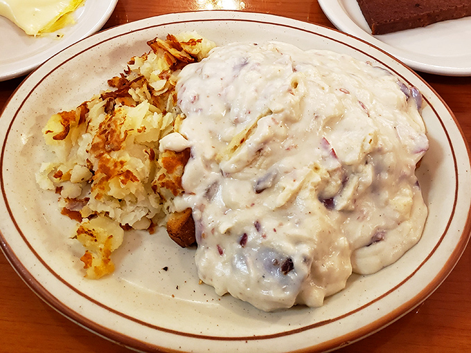 Country fried steak smothered in creamy gravy alongside golden hash browns &ndash; the kind of plate that makes you want to hug the cook and take a nap simultaneously.