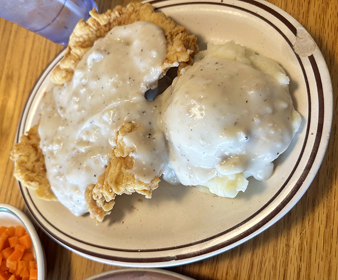 Country fried steak swimming in gravy&mdash;the kind of dish that makes you want to hug the cook and thank your cardiologist in the same breath.