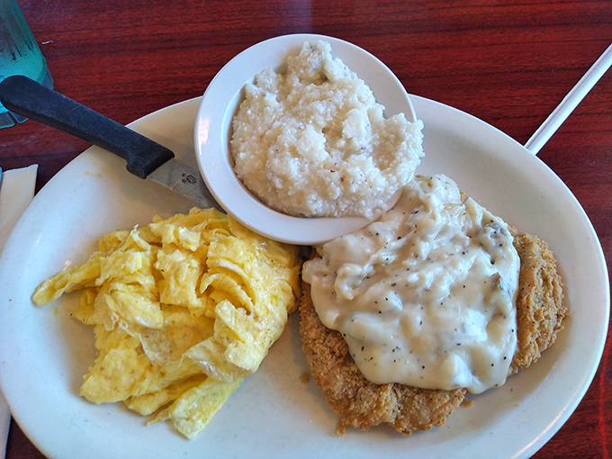 Country fried perfection with gravy, eggs, and grits &ndash; the holy trinity of Southern breakfast that makes Yankees weep with joy.