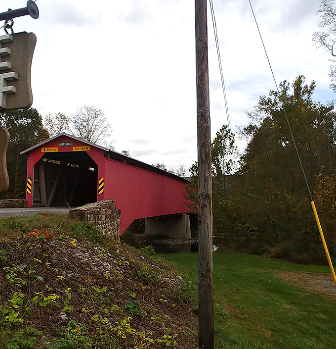 Autumn's palette complements the bridge's weathered crimson exterior, a scene straight from a Norman Rockwell painting come to life.