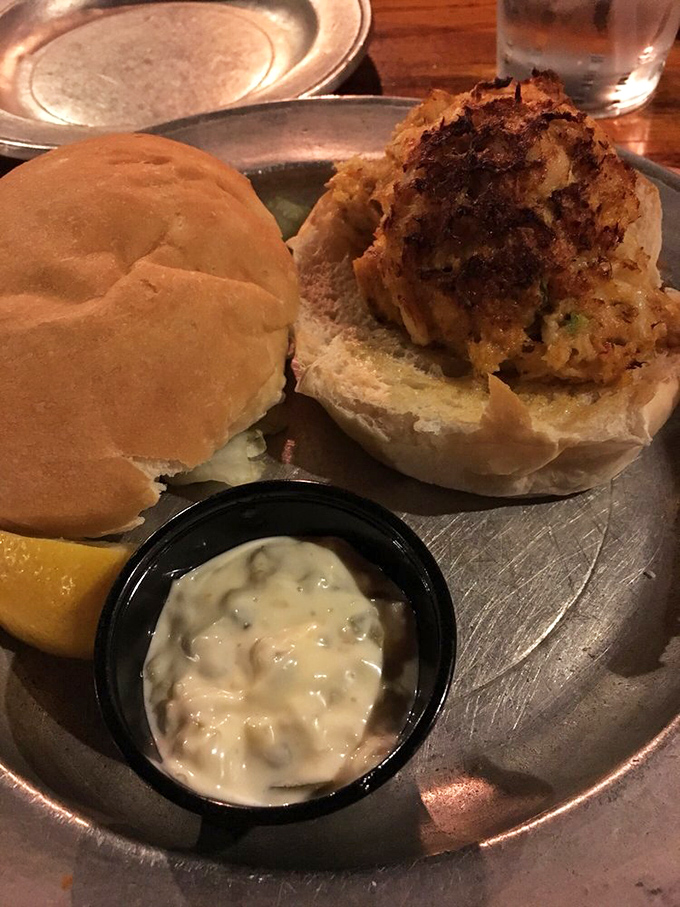 This crab cake sandwich isn't just a meal—it's maritime treasure on a bun, with tartar sauce that should be considered essential infrastructure.