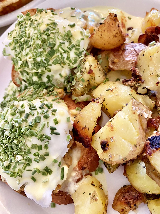 Eggs Benedict gets the royal treatment with perfectly poached eggs draped in hollandaise and sprinkled with fresh chives&mdash;breakfast aristocracy at its finest.